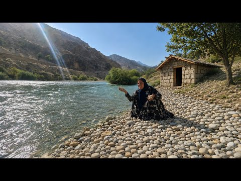 A hardworking mother gathers beautiful stones by the river to decorate her dream cottage.