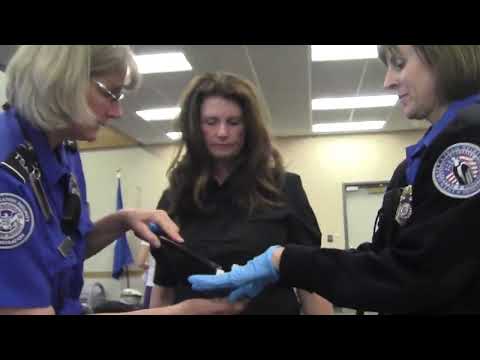 TSA agent in training patting down a woman, demonstrating how to pat ...