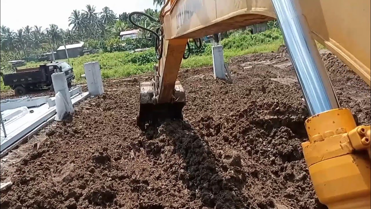 Hydraulic excavator backfilling foundation - YouTube