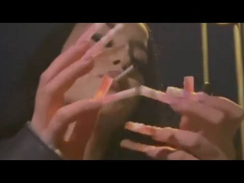 A girl with long nails smokes a cigarette, litters and spits