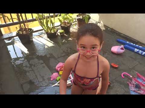 Laís brinca de banho de mangueira com seu pai...