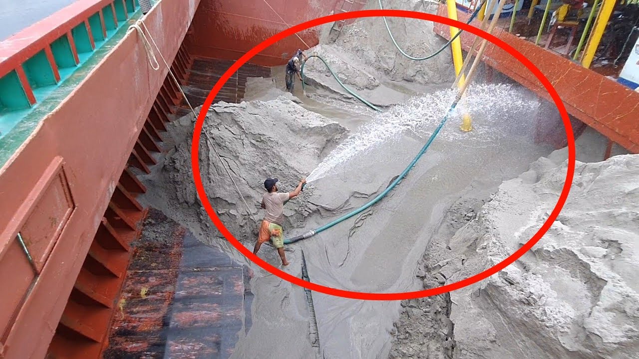 Sand is being unloaded from large ships with powerful dredger machines ...