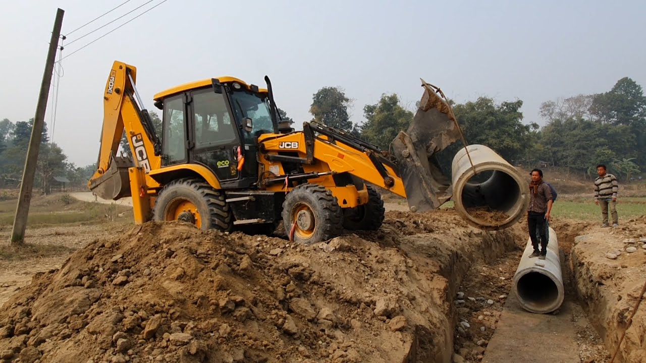 JCB Backhoe Machine Lifting Heavy Culvert Pipe and Installing in Drain ...