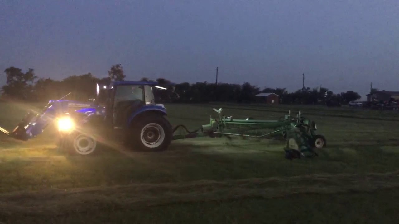 New holland W/John Deere 700 rake at night - YouTube