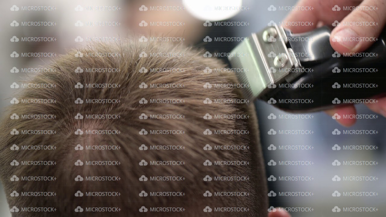 Young man's haircut in Barbershop. Close-up of master clipping hair ...