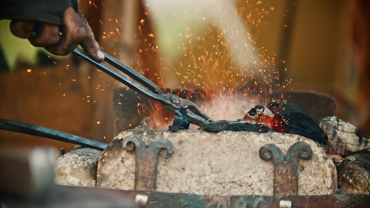 blacksmith working with a horseshoe in his workshop heating up the ...