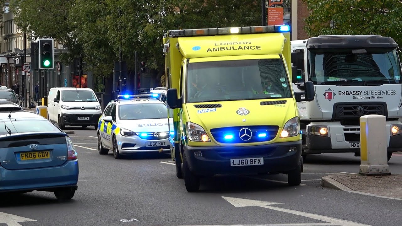 Emergency ambulance and police car make progress through oncoming ...