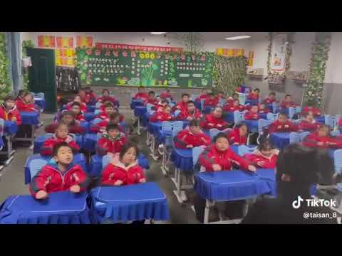 Chinese school children exercising at their desks.