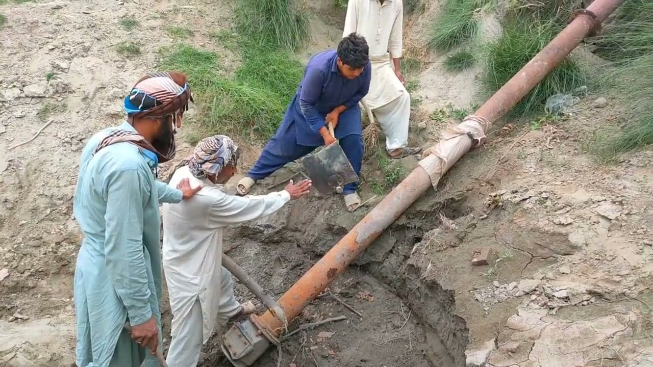 Two men lifted the water pipe to run the water tube well come sanke ...