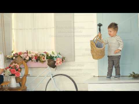 Happy loving couple sitting in swing and talking while their son playing near door in garden at home