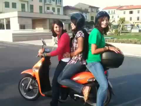 three girls play on one moped