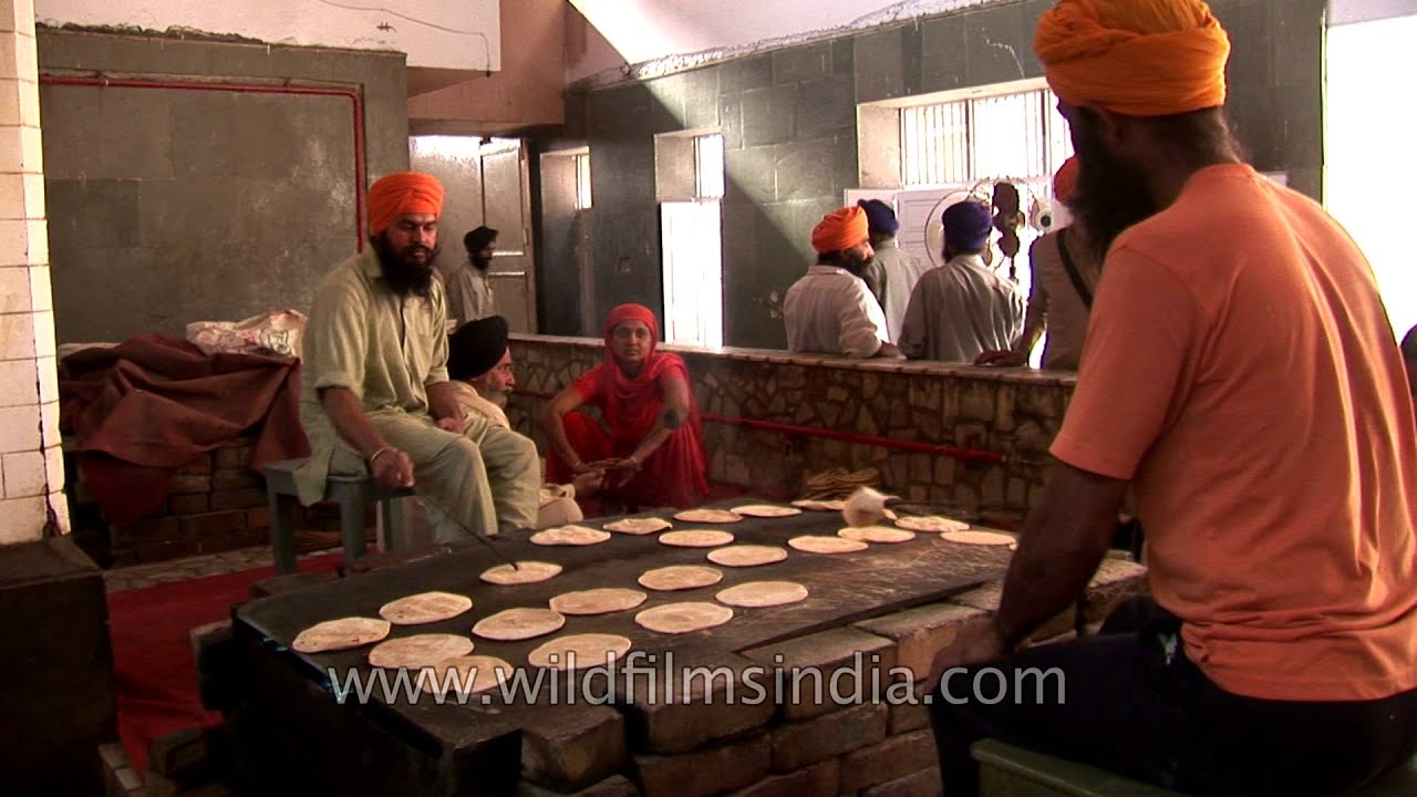 Volunteers cook chapatis in the Golden temple kitchen, Amritsar, India ...