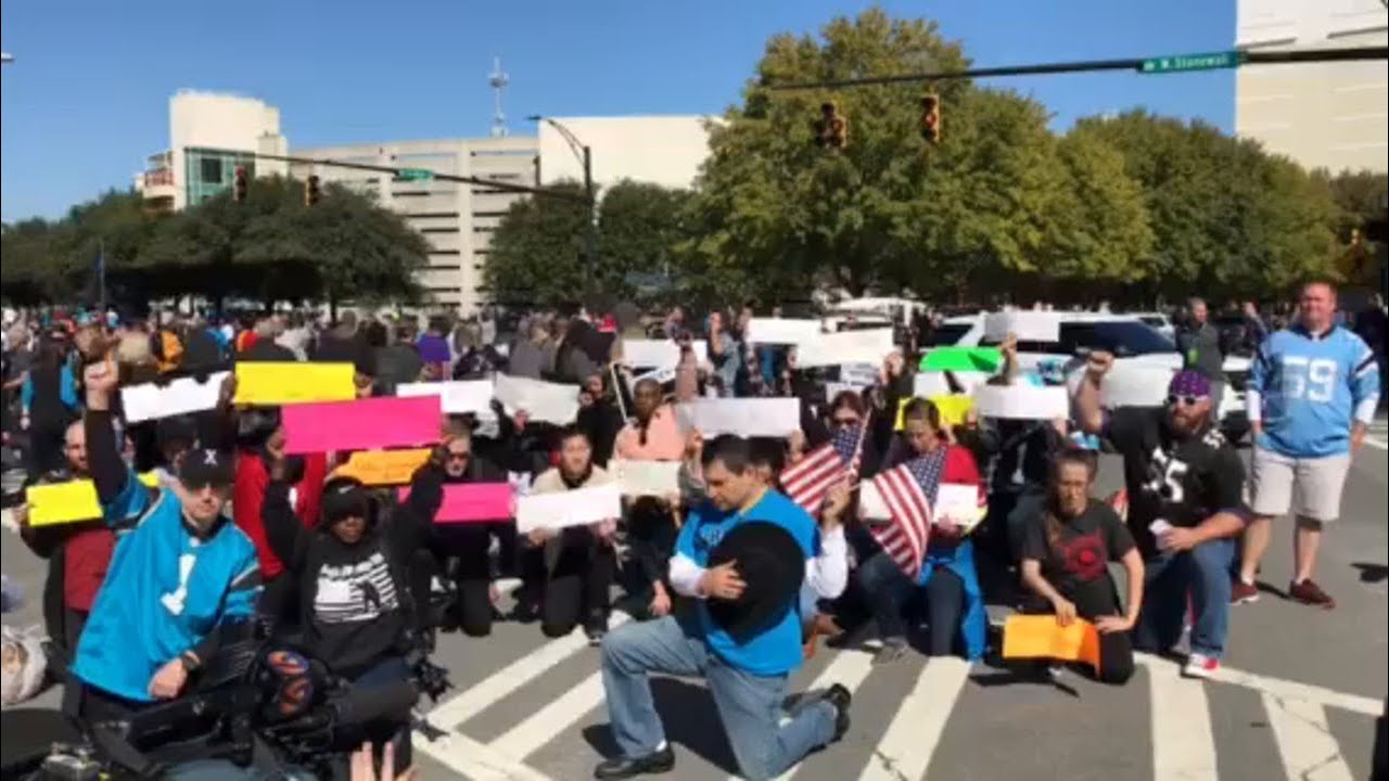Protesters kneel during national anthem outside Bank of America Stadium ...