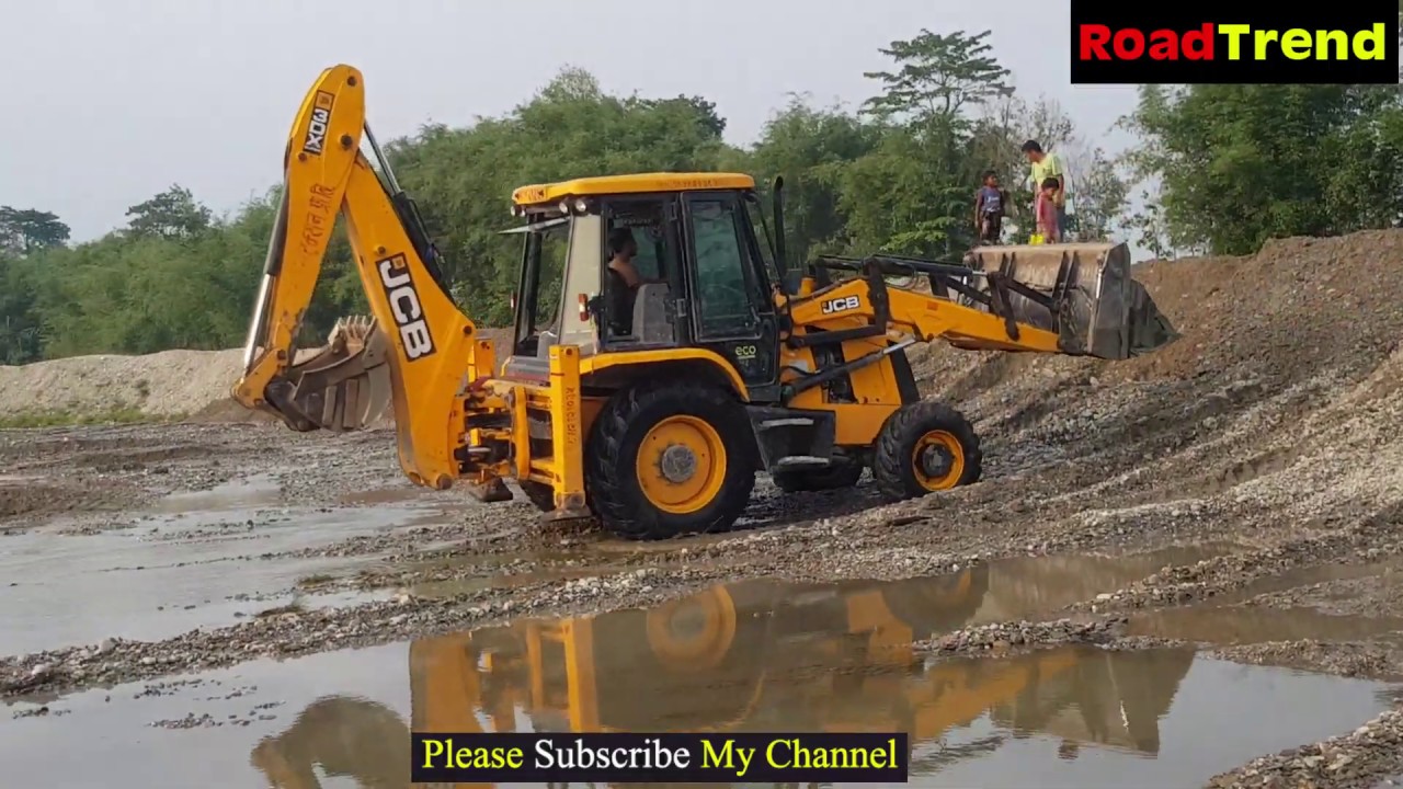 JCB machine pushing and collecting sand and moving the mouth of the ...