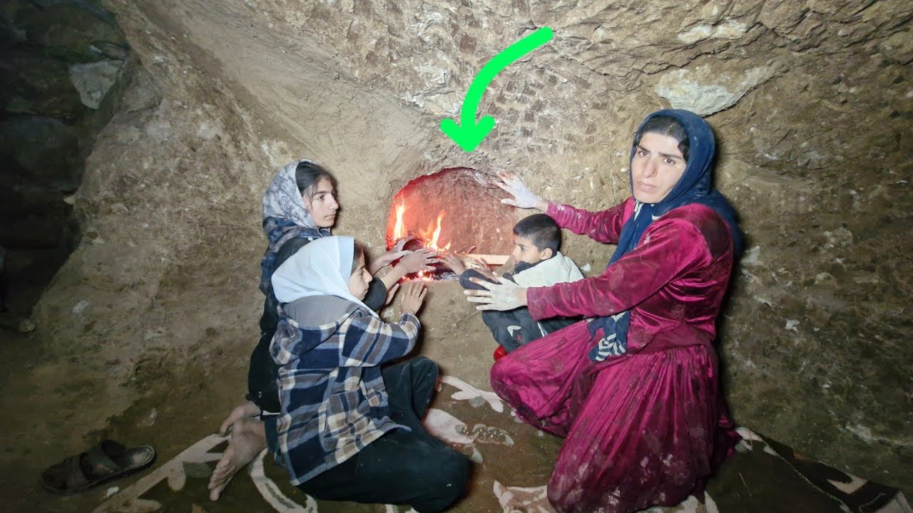 A nomadic mother builds a fireplace for her children inside a cave ...