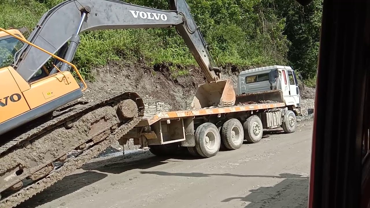 Backhoe loading in truck trailer - YouTube