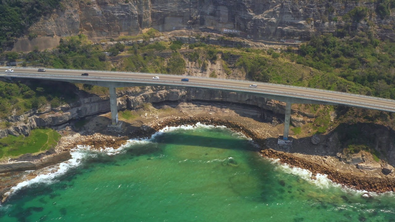 Aerial drone view of the scenic Sea Cliff Bridge - YouTube