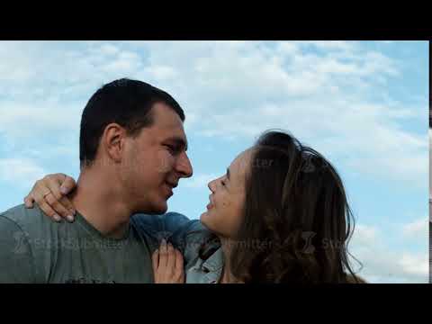 A young man kisses his lucky girlfriend.