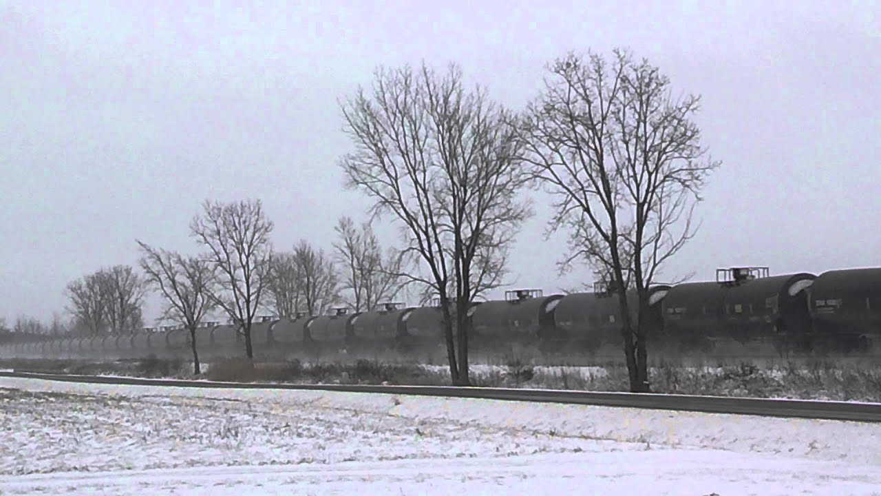 BNSF 977 Leads Crude Oil Train Kicking Up Snow - YouTube