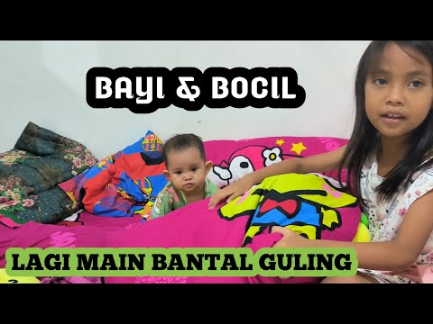 Bocil lagi main bantal guling di atas kasur