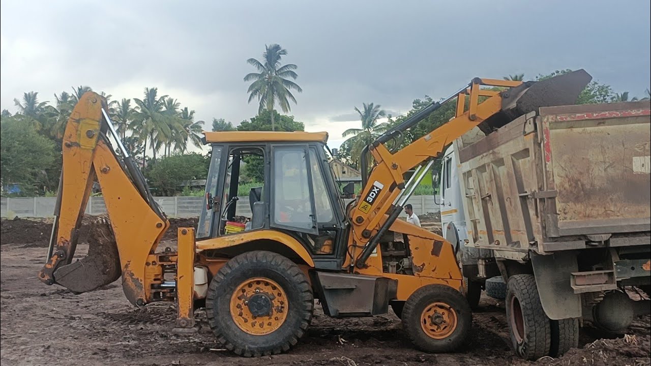 JCB Excavator Machine work with two big Dumpers ground level in farm ...