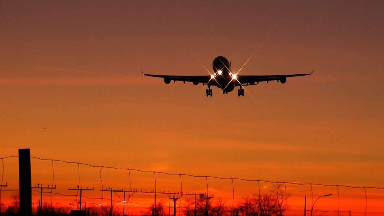 Plane Landing At Sunset