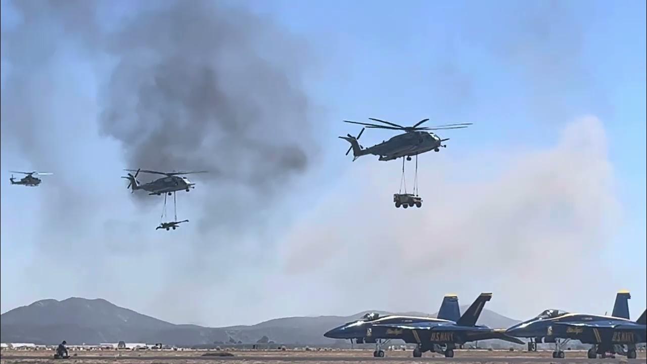 U.S. marine corps 2 MH 53 super sea stallions lifting an light mobility vehicle and artillery ...