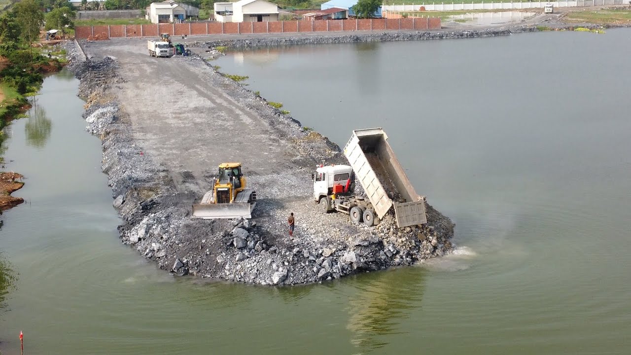 Excellent Techniques skill operator Dozer pushing Stone into the water ...