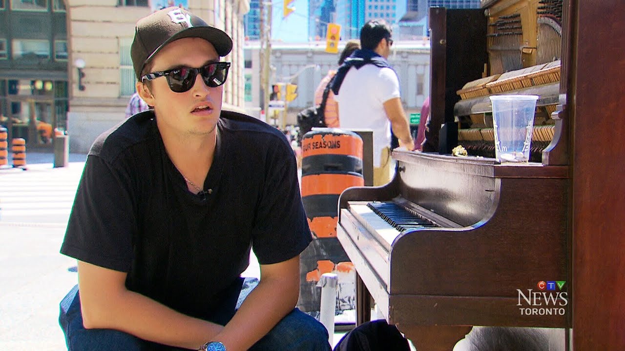 Piano busker pushes piano 2 kilometres to play - YouTube