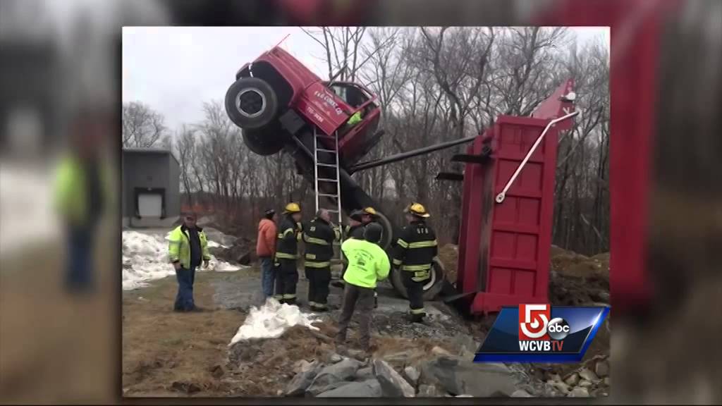 Woman rescued after dump truck tips - YouTube