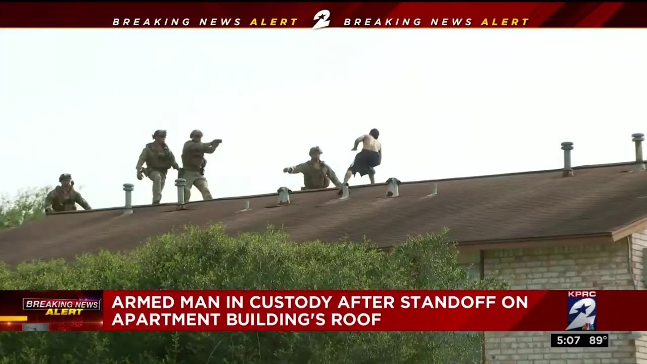 Armed man in custody after standoff on apartment building's roof - YouTube