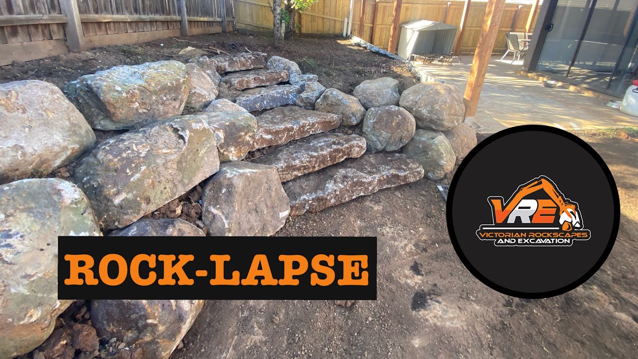 Transforming a backyard with a natural rockwall - YouTube