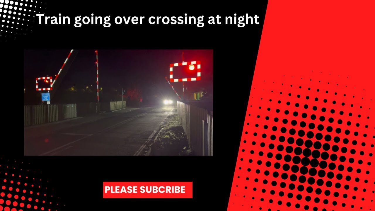Train going over level crossing at night - YouTube