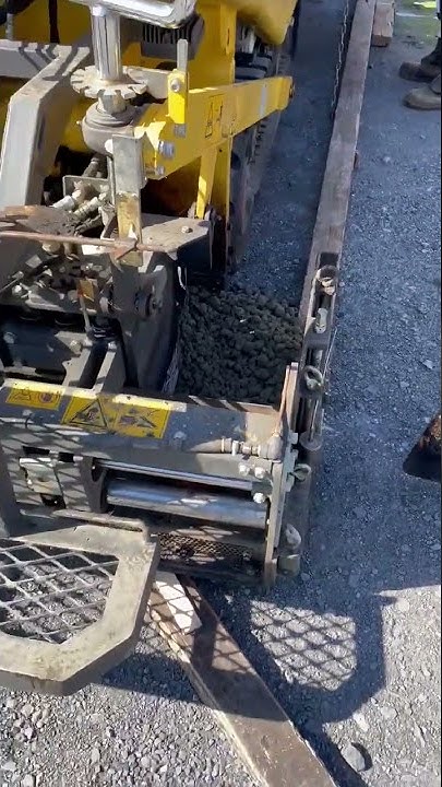 アスファルトフィニッシャで施工されるオワコンの様子について。施工中にタイヤが往来するくらいだから直後から駐車場として利用できるのがオワコンの強み。土間コンと砕石舗装のいいとこ取りのあいのこ 