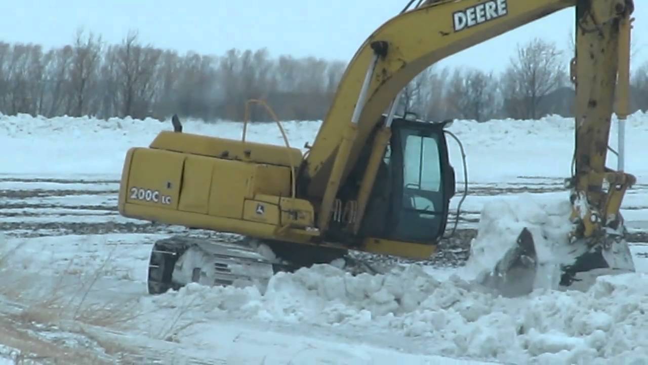 200 JD excavator cleaning snow out of ditches - YouTube