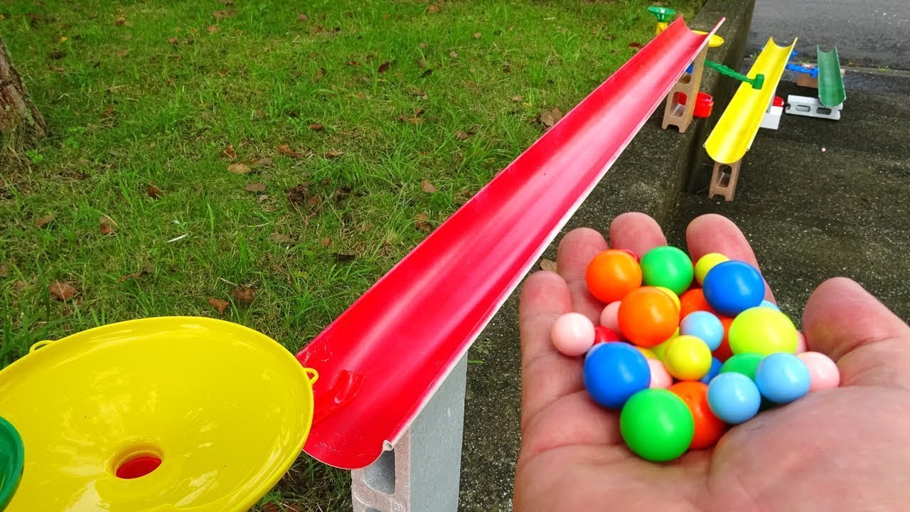 Marble run race - rain gutter + big colorful ball + sandy beach tunnel ...