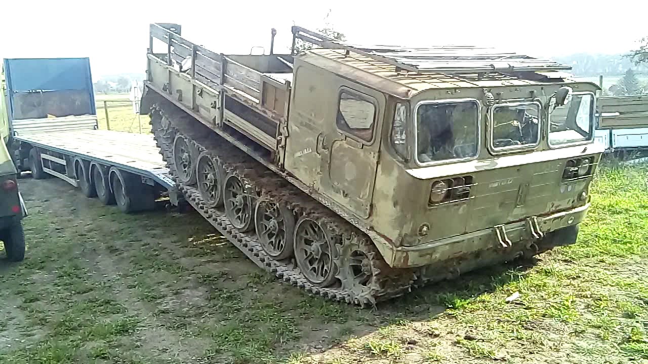 ATS-59G soviet artillery tractor (based on a t-54 chassis) being loaded ...
