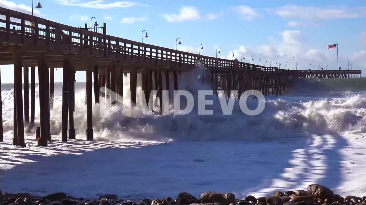 Huge waves crash on a California beach and pier during a very large ...