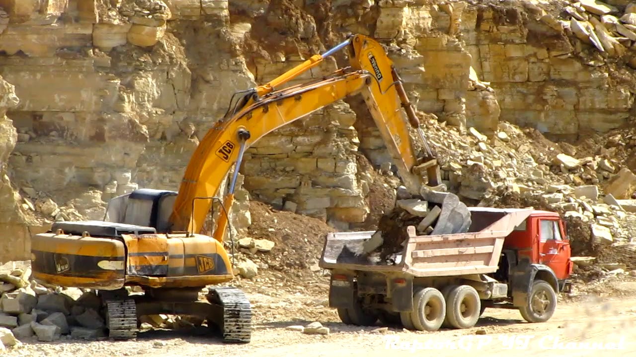 JCB JS330 excavator loads dump trucks in limestone quarry - YouTube