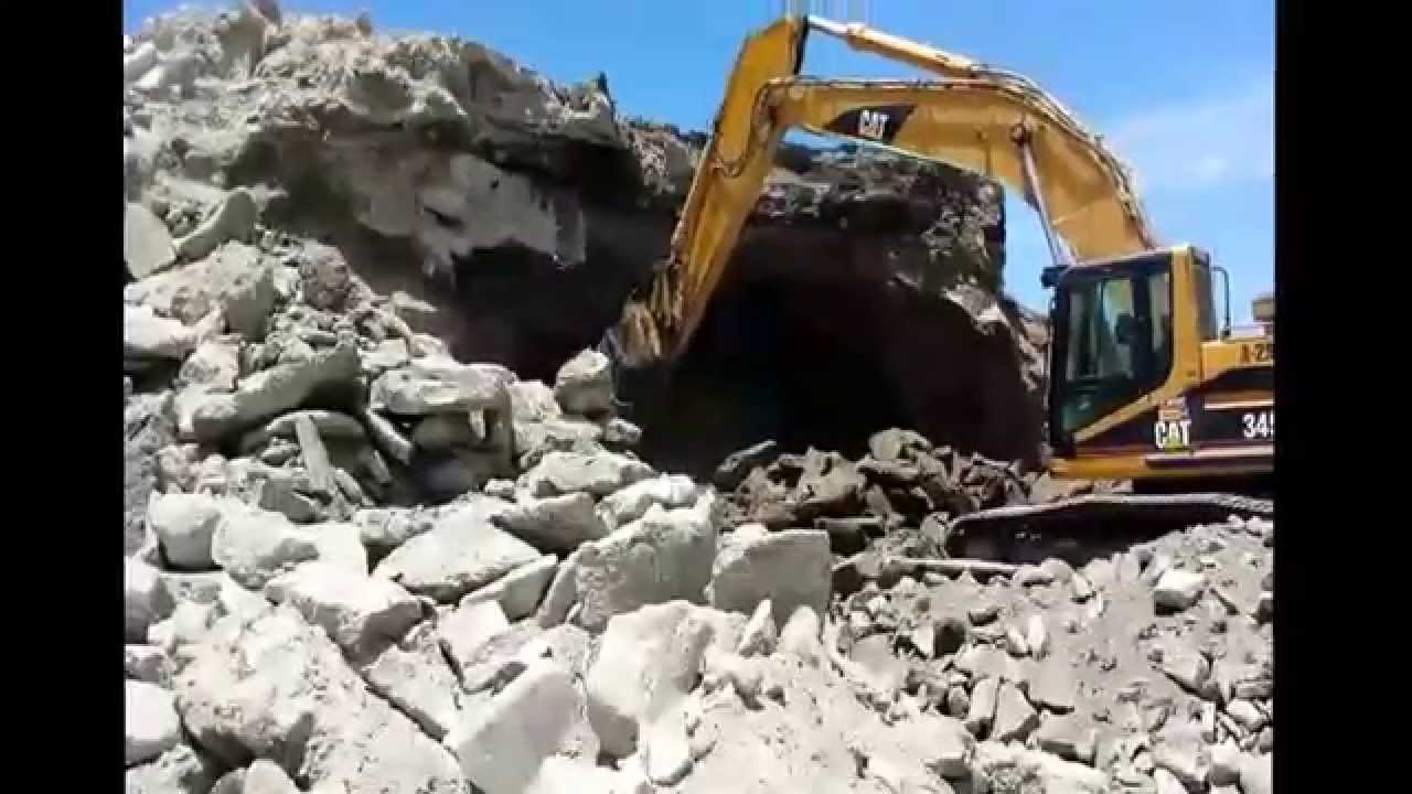 Heavy equipment excavator with muncher sizing concrete - YouTube