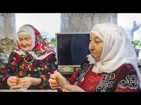 Village life in Russia. Tatar grandmother cooks food in the oven.