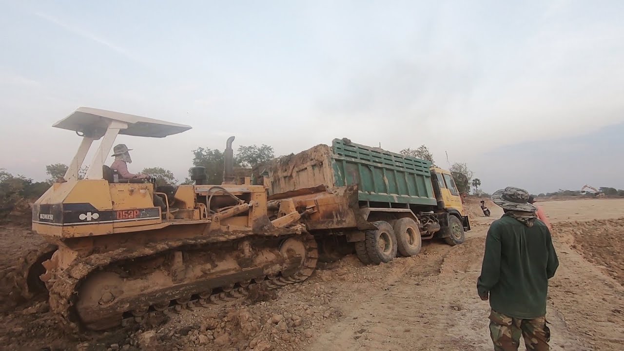 Full soil loading truck stuck in mud and push by Excavator and ...