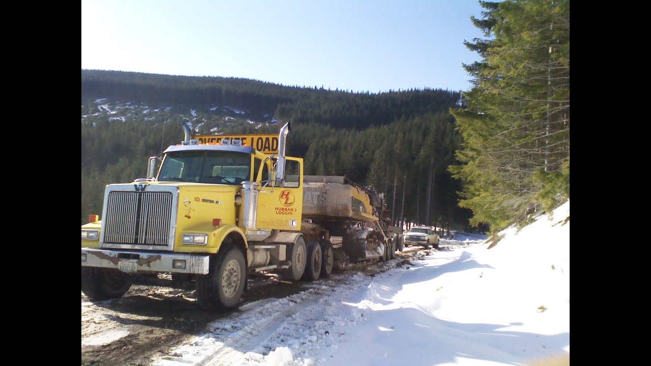 Lowboy with processer on snowy logging roads - YouTube