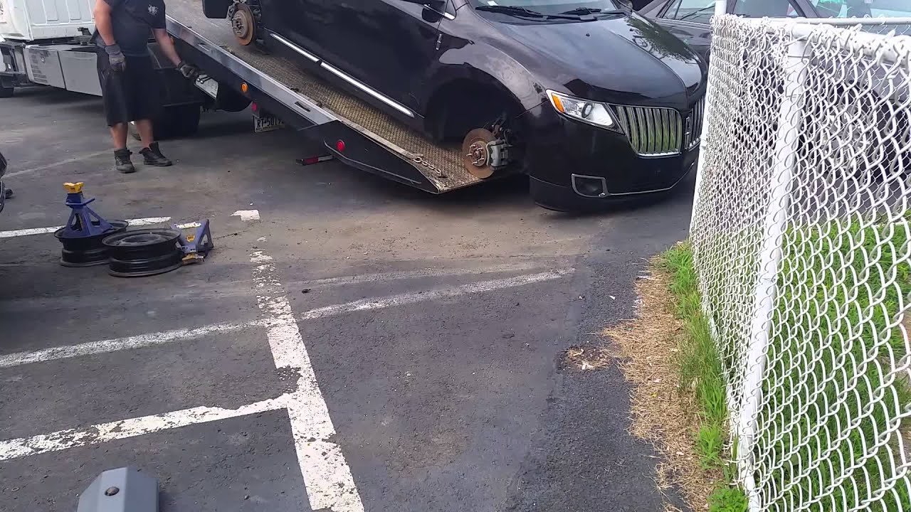Car without tires taken off a flat bed - YouTube