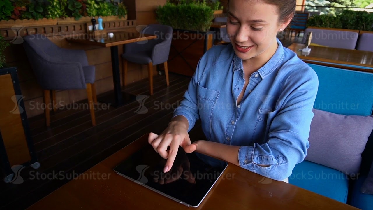 Cheerful girl working with tablet at restaurant table - YouTube