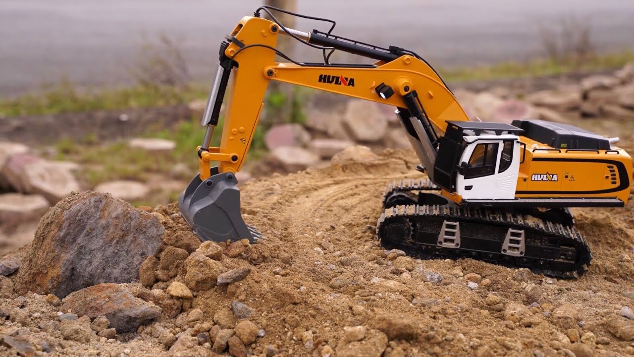 Excavators Huina 1599 scoop soil to create a space for dump trucks to ...