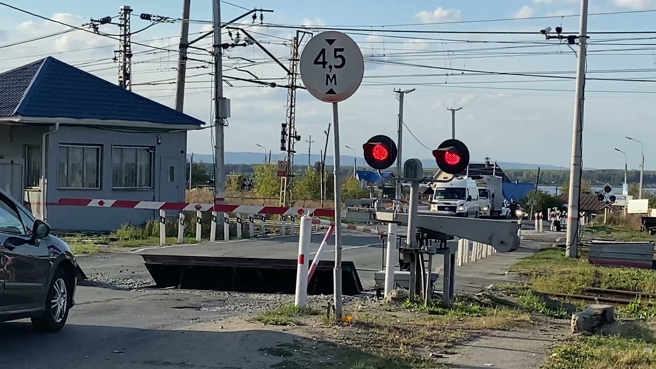 регулируемый железнодорожный переезд со шлагбаумом и барьерами ...