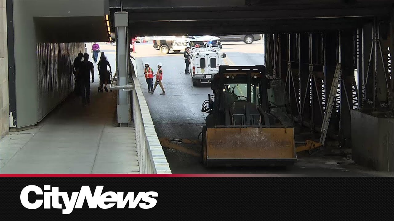 Backhoe gets stuck under bridge in downtown Calgary - YouTube