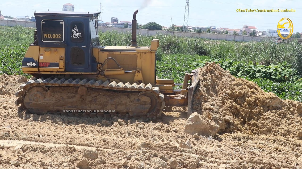 Road construction by dozer pushing, motor grader grading, roller ...