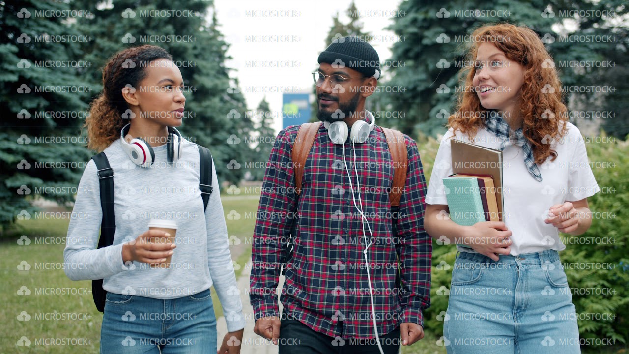 Group of mates walking outdoors on campus with books and coffee ...